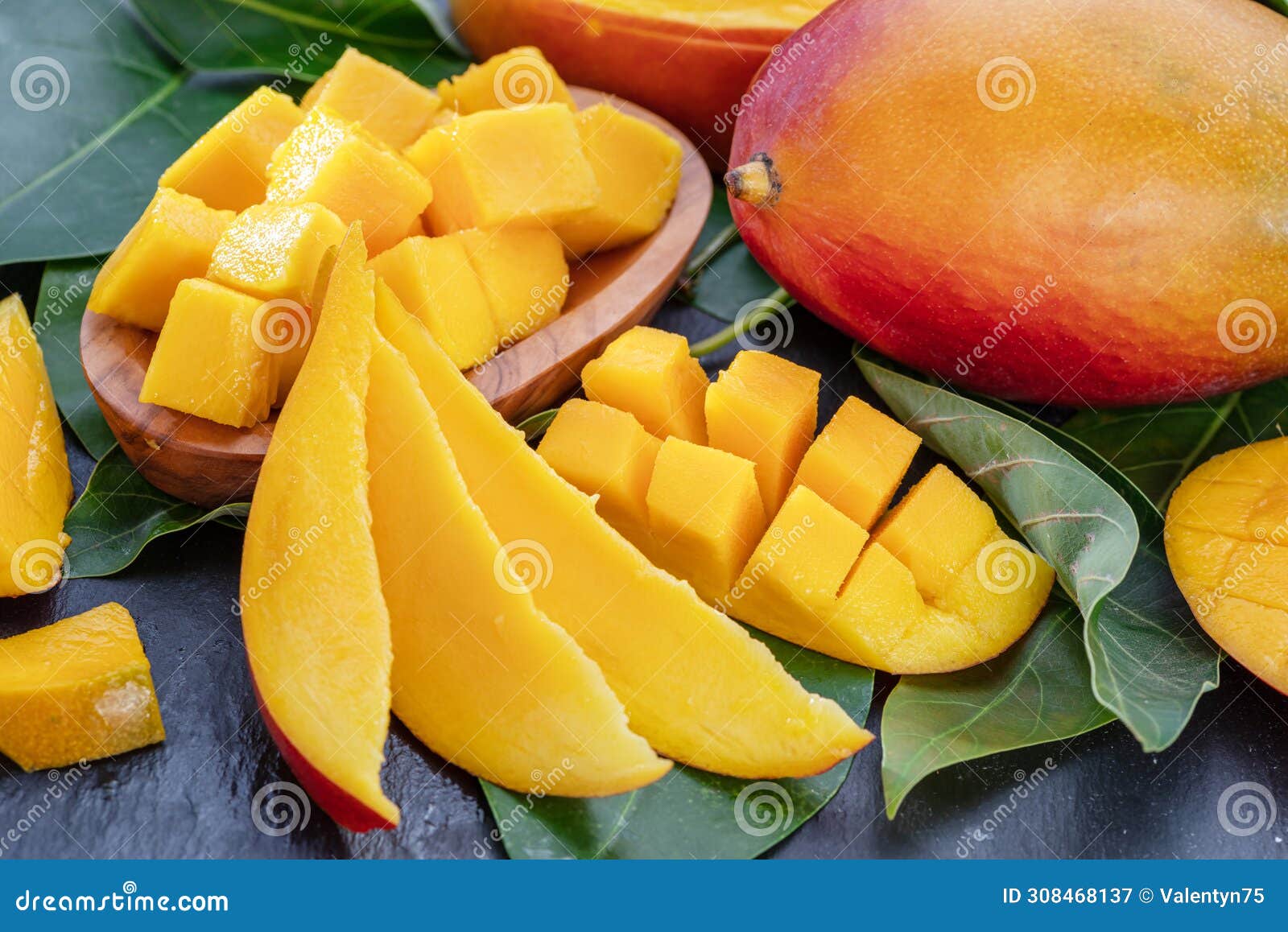 Ripe Mango Fruits with Slices and Mango Leaves on a Gray Stone Table ...