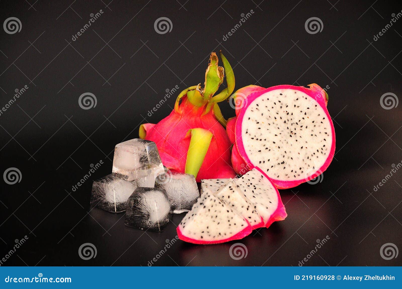 Ripe Pitaya Fruit Cut into Pieces and Cubes of Melted Ice on a Black ...