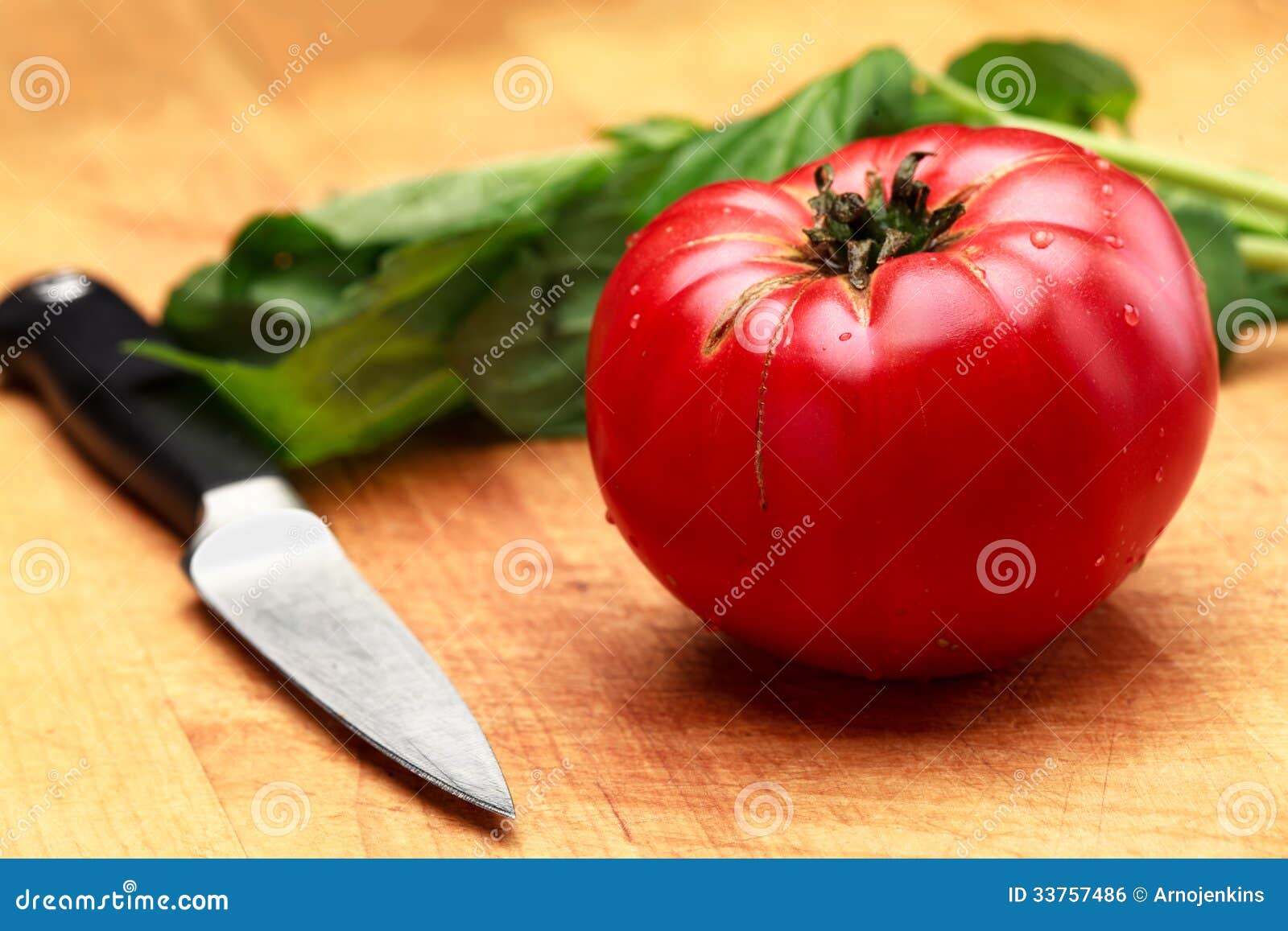 Ripe Tomato Ready To Cut with Fresh Basil on Cutting Board Stock Photo ...