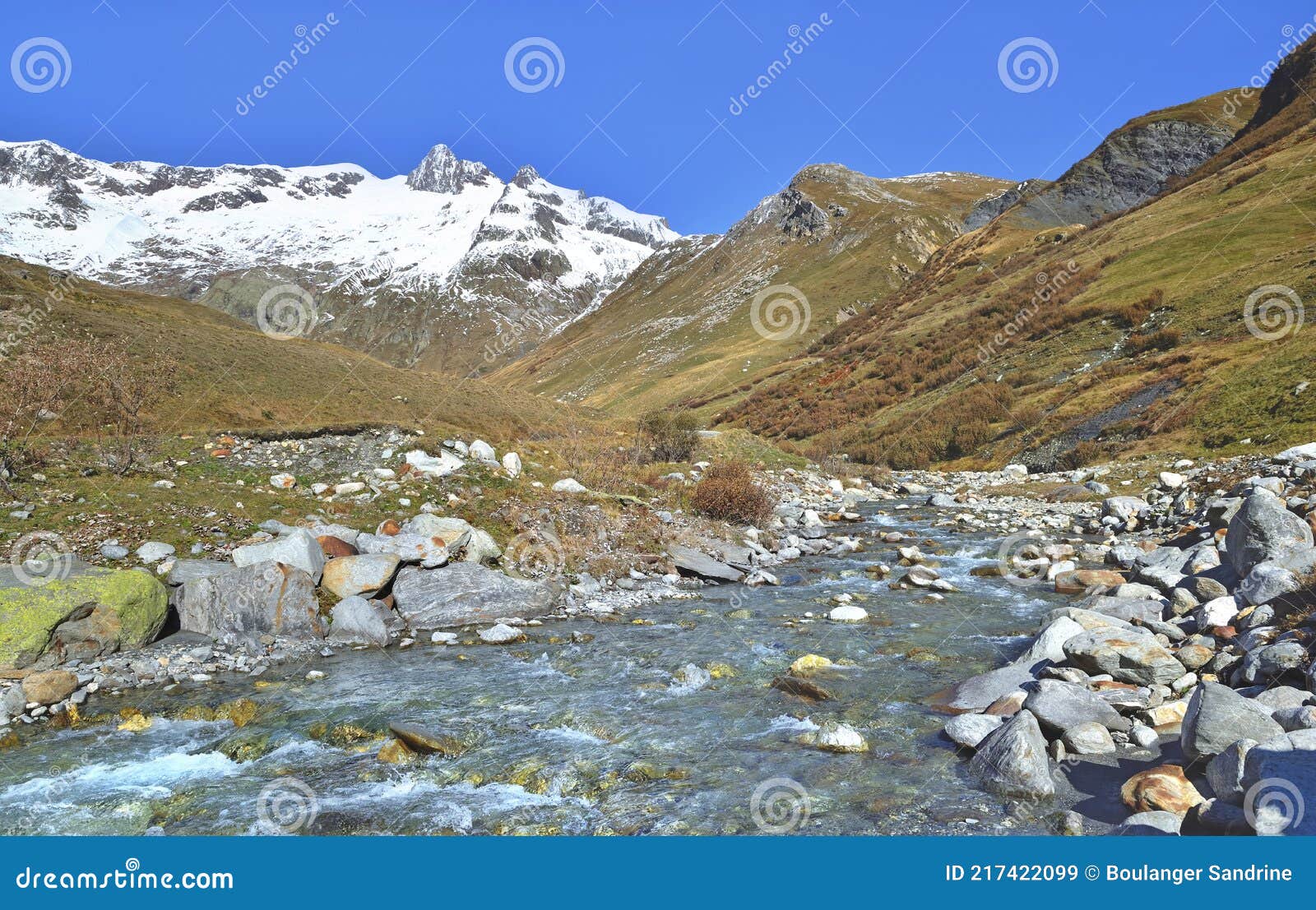 River Flowing in a Meadow with Mountain with Snow Stock Image - Image ...