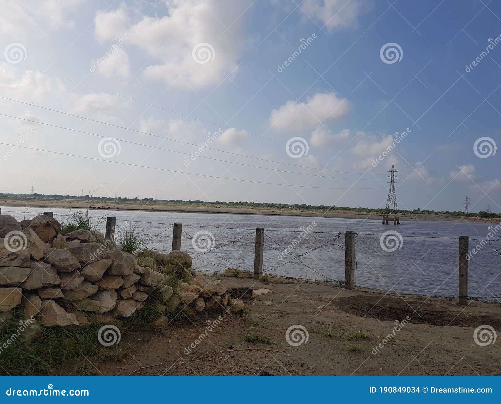 River View with Rocks and Electricity Tower Inside a River Stock Photo ...