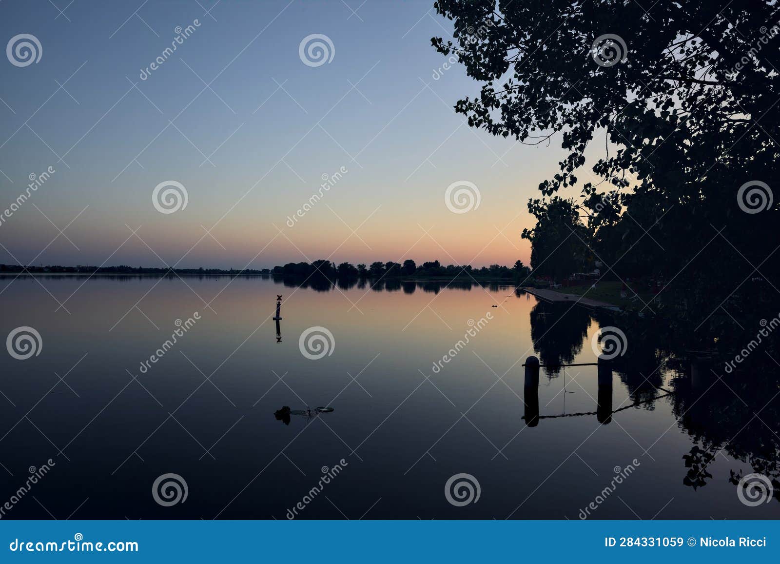 Riverside at Sunset with Its Reflection Casted in the Water at Sunset ...