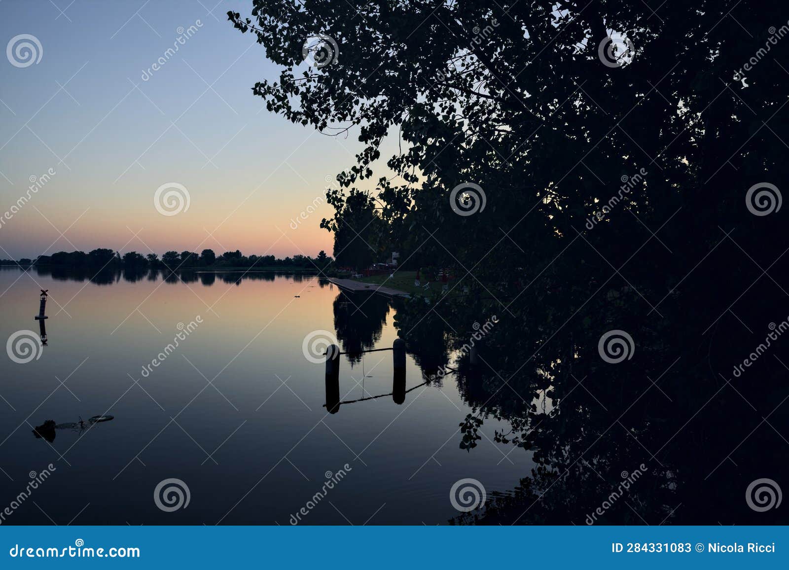 Riverside at Sunset with Its Reflection Casted in the Water at Sunset ...