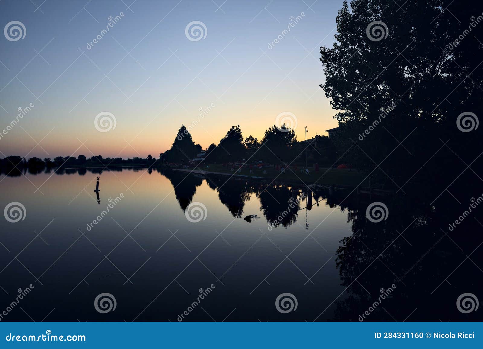Riverside at Sunset with Its Reflection Casted in the Water at Sunset ...