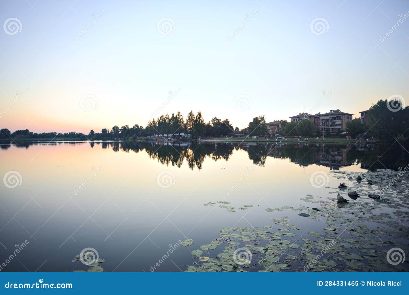 Riverside at Sunset with Its Reflection Casted in the Water at Sunset ...