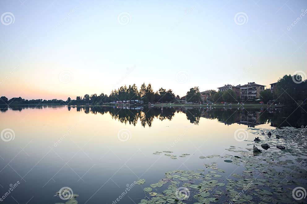 Riverside at Sunset with Its Reflection Casted in the Water at Sunset ...