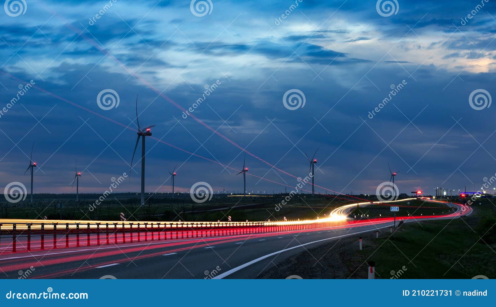 A Road with Car Lights at Sunset with Wind Generators Stock Image ...