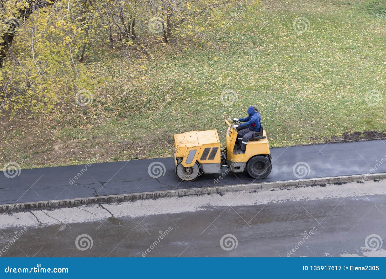 Road Construction Worker Compactes Fresh Steaming Asphalt With Roller ...