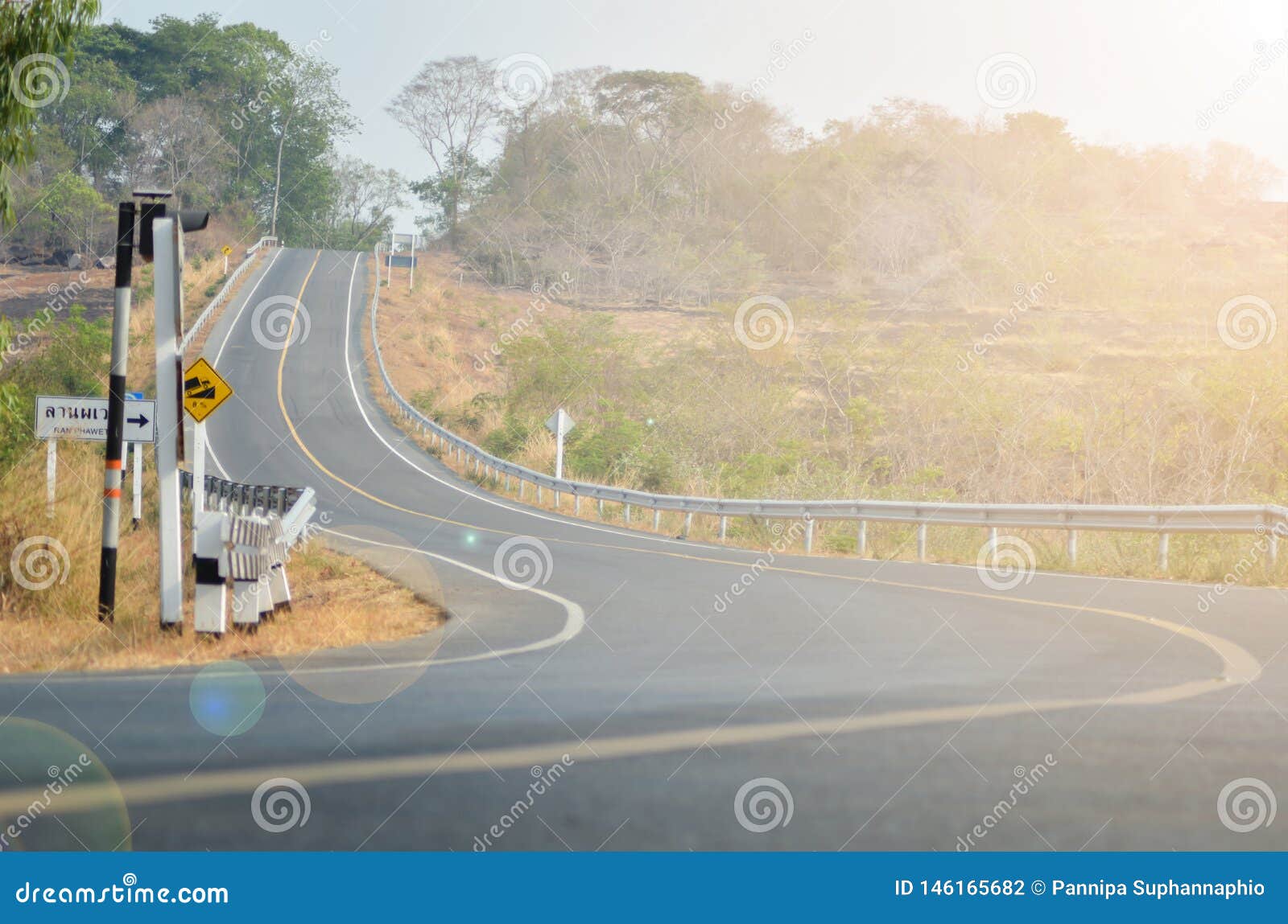 The Road Has a Yellow Line and There is a Warning Sign on the Steep ...