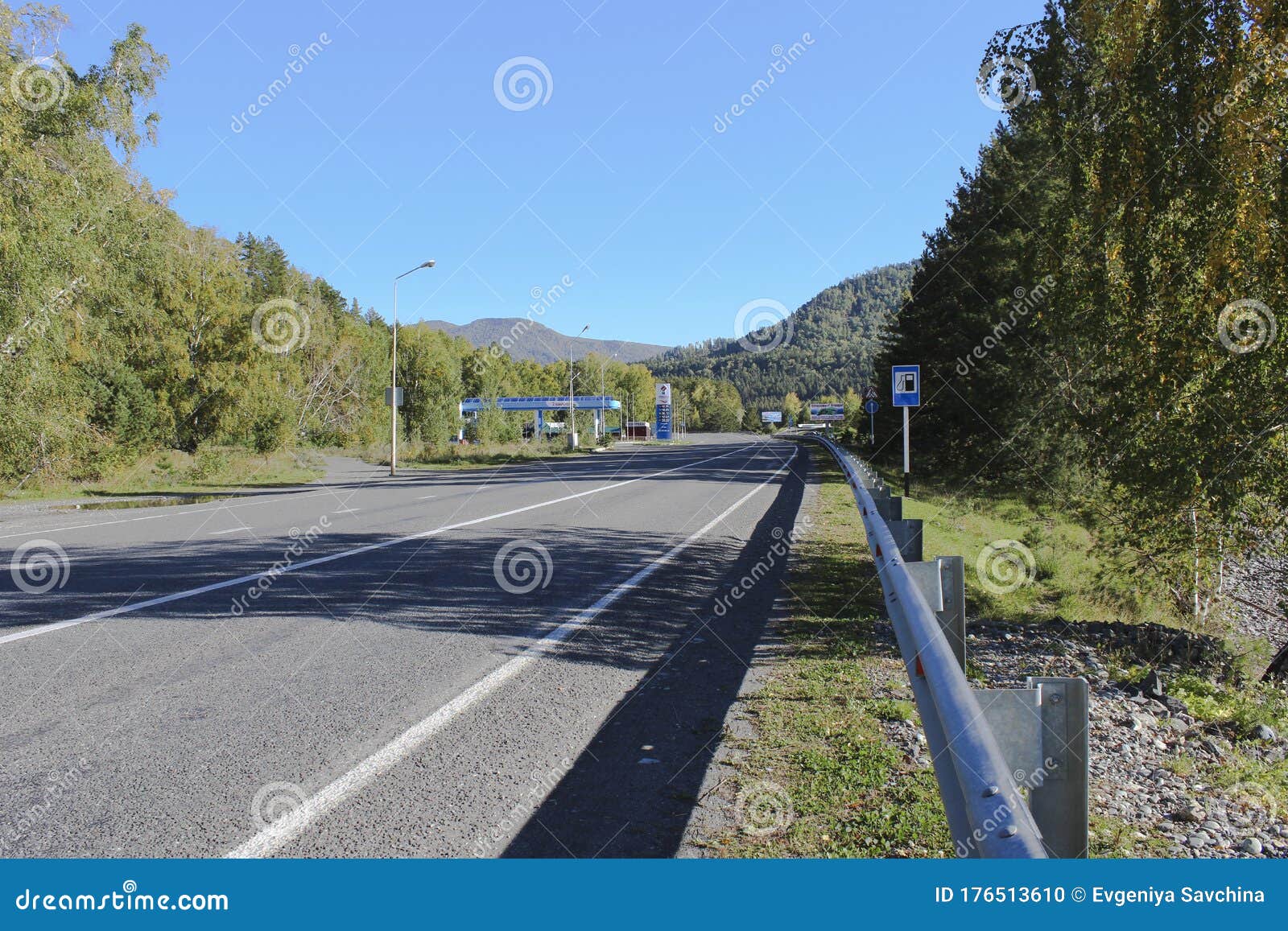 Road in Hilly Terrain. Sign on the Road and Refueling Stock Photo ...