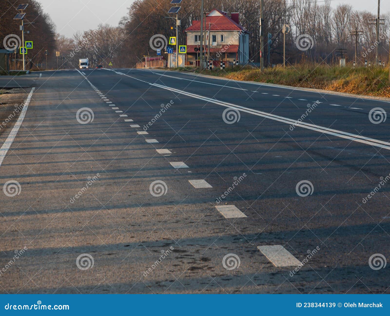 Road Lined with Autumn Trees. Cross Hatching Road Marks Line the Centre ...