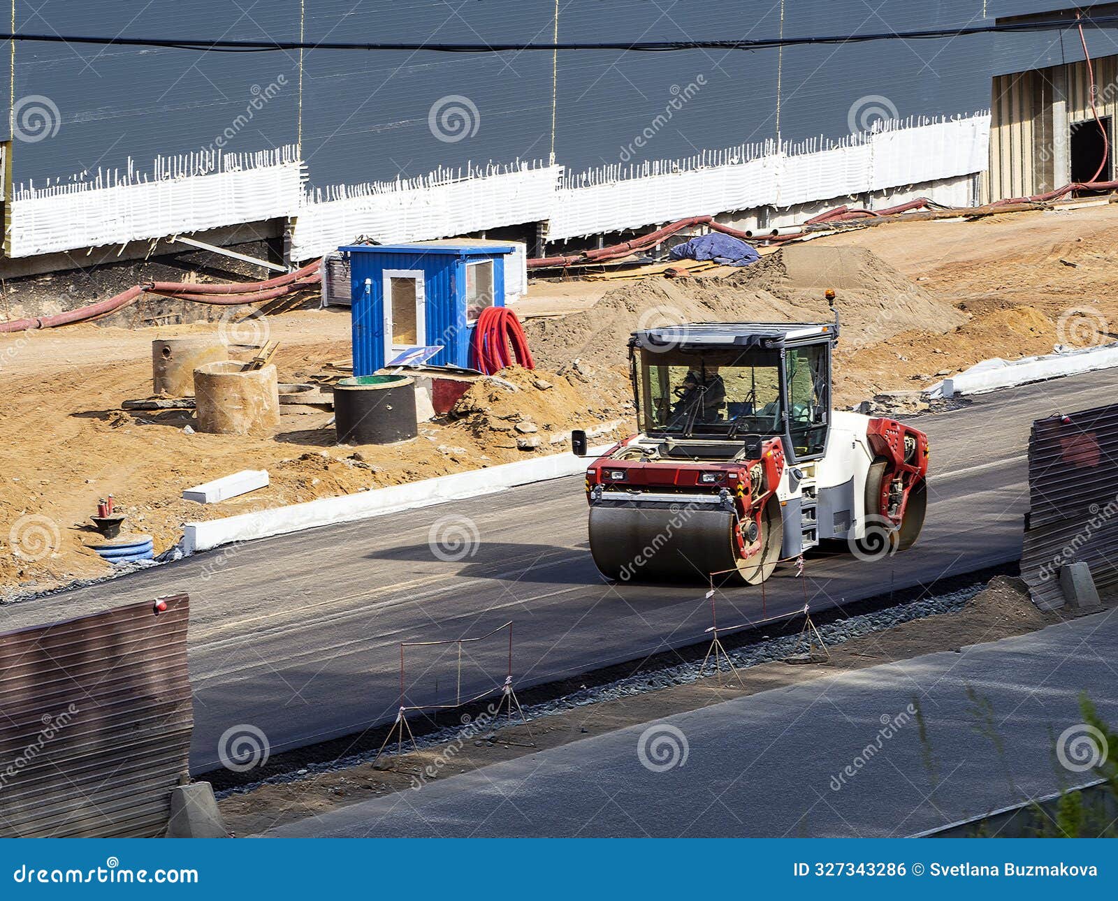 A Road Roller Compacts the Asphalt Surface of the Road. the ...