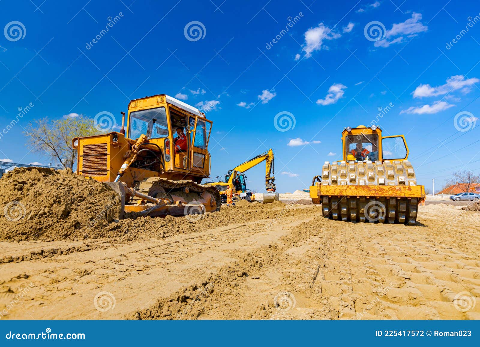 Road Roller with Spikes and Earthmover are Working at Construction Site ...