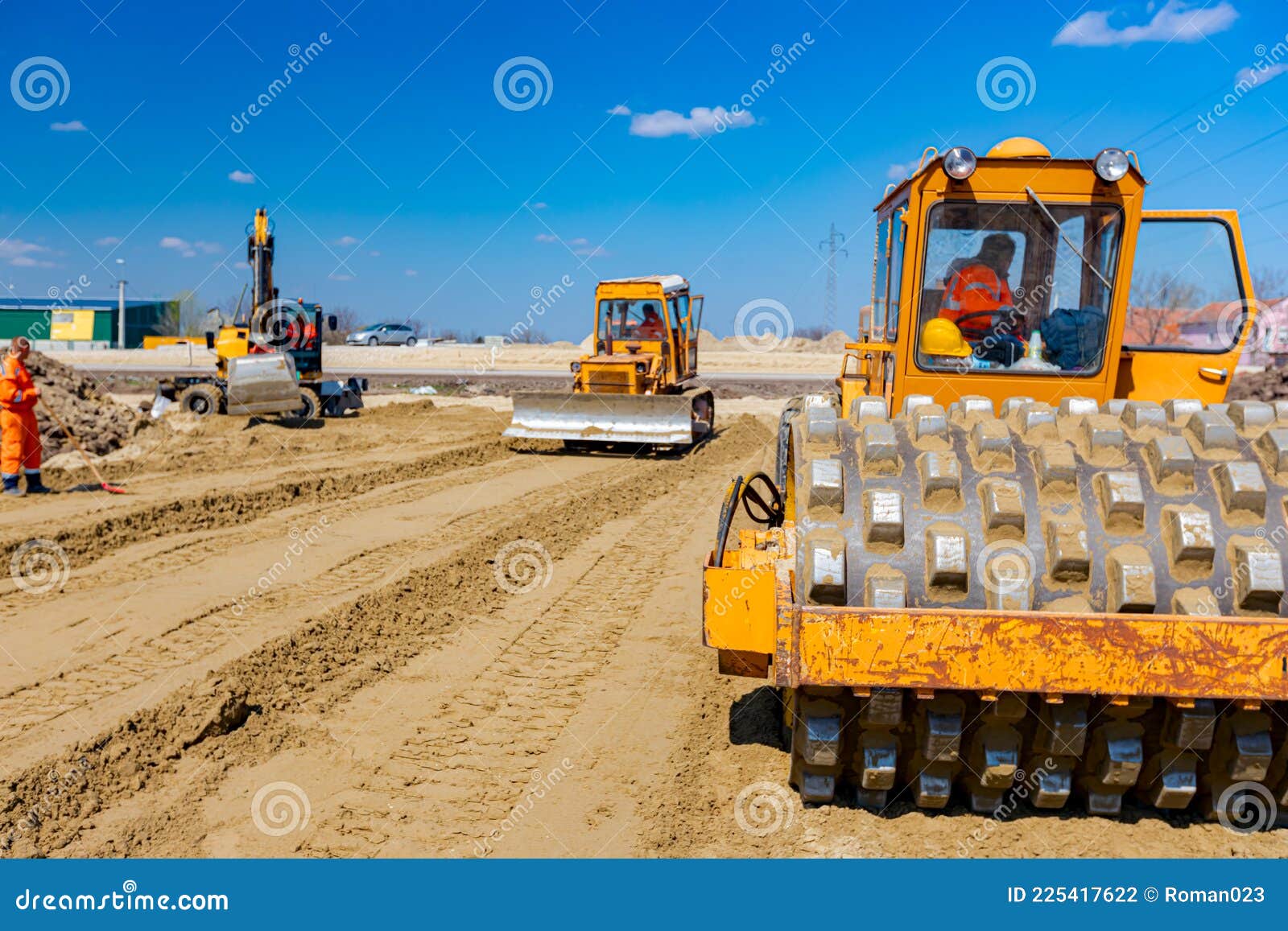 Road Roller with Spikes and Earthmover are Working at Construction Site ...