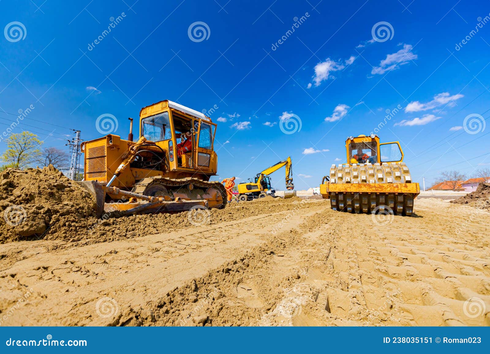 Road Roller with Spikes and Earthmover are Working at Construction Site ...