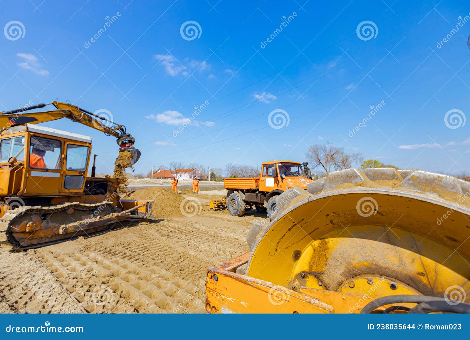 Road Roller with Spikes and Earthmovers are Working at Construction ...