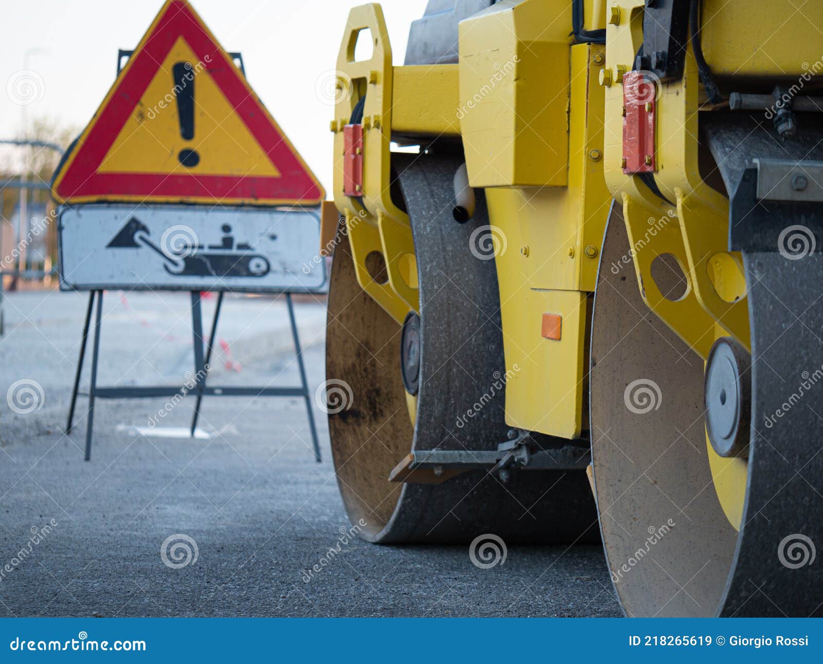 Road Sign Showing Work in Progress and Big Machine for Asphalt ...