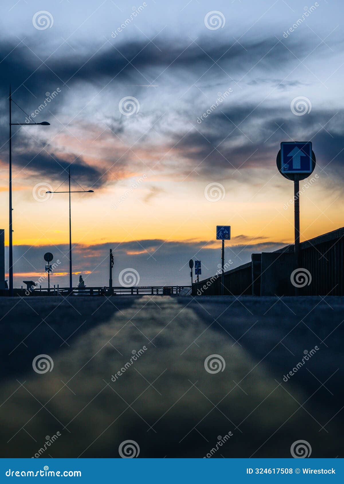 A Road with Street Signs and Lampposts at Sunset, Featuring a Dramatic ...