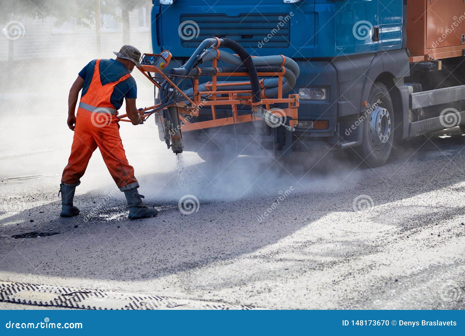 Road Worker Repairing Asphalt Coating, Using a Manipulator. Pitching ...