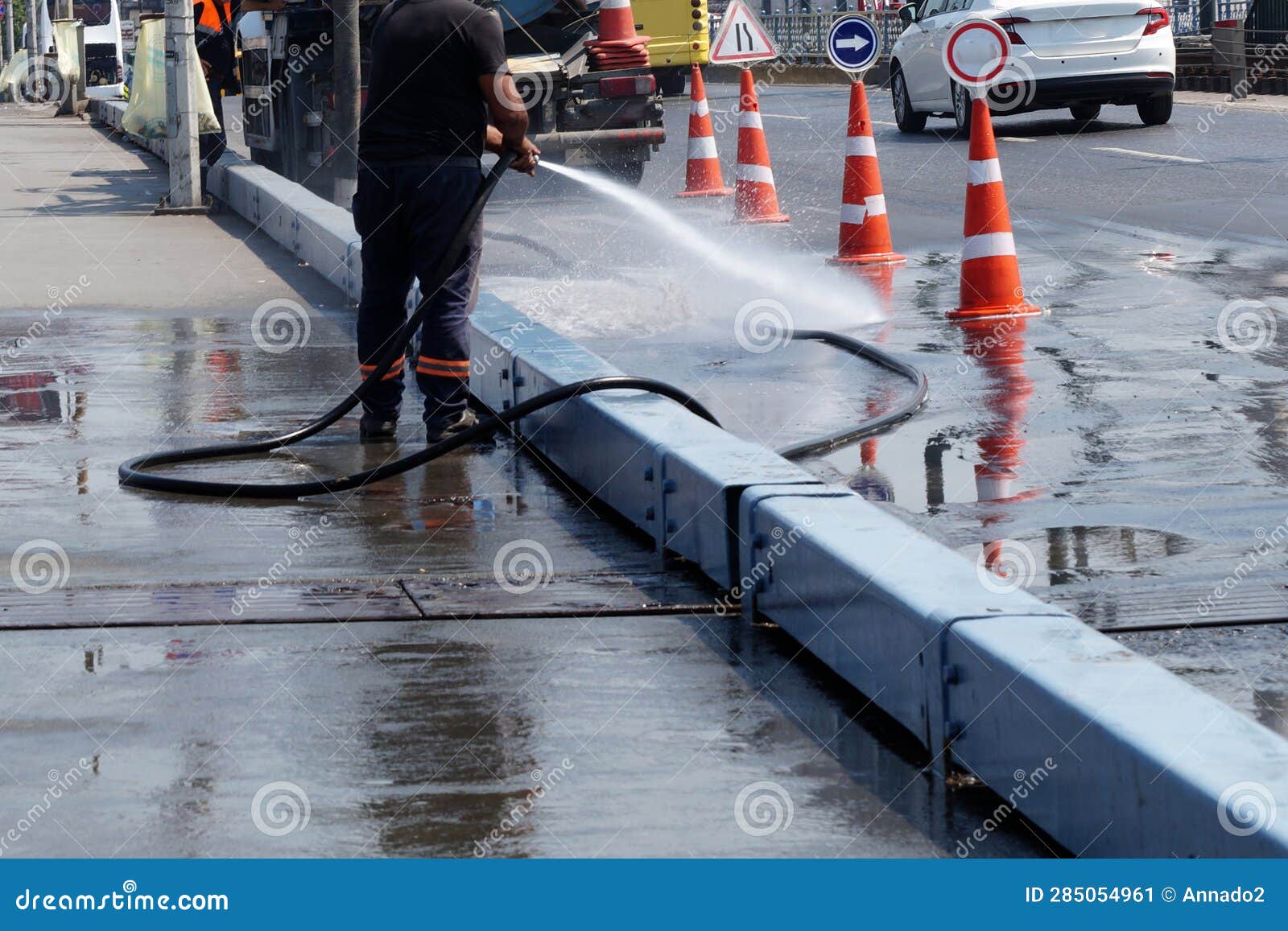 Road Worker Washing the Roadway with Water from a Hose Stock Image ...