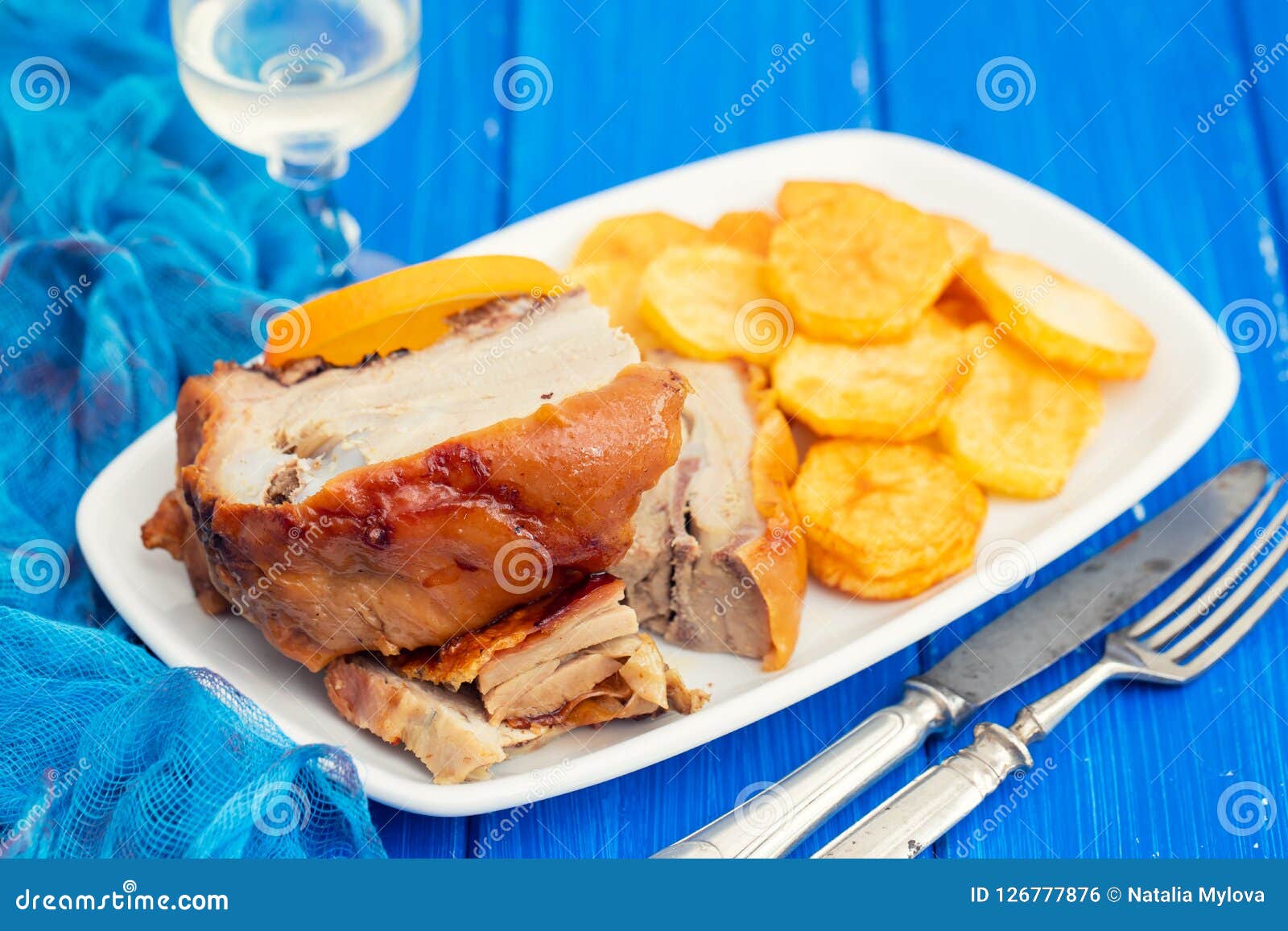 Roasted Piglet with Potato Chips and Orange on White Plate Stock Photo ...