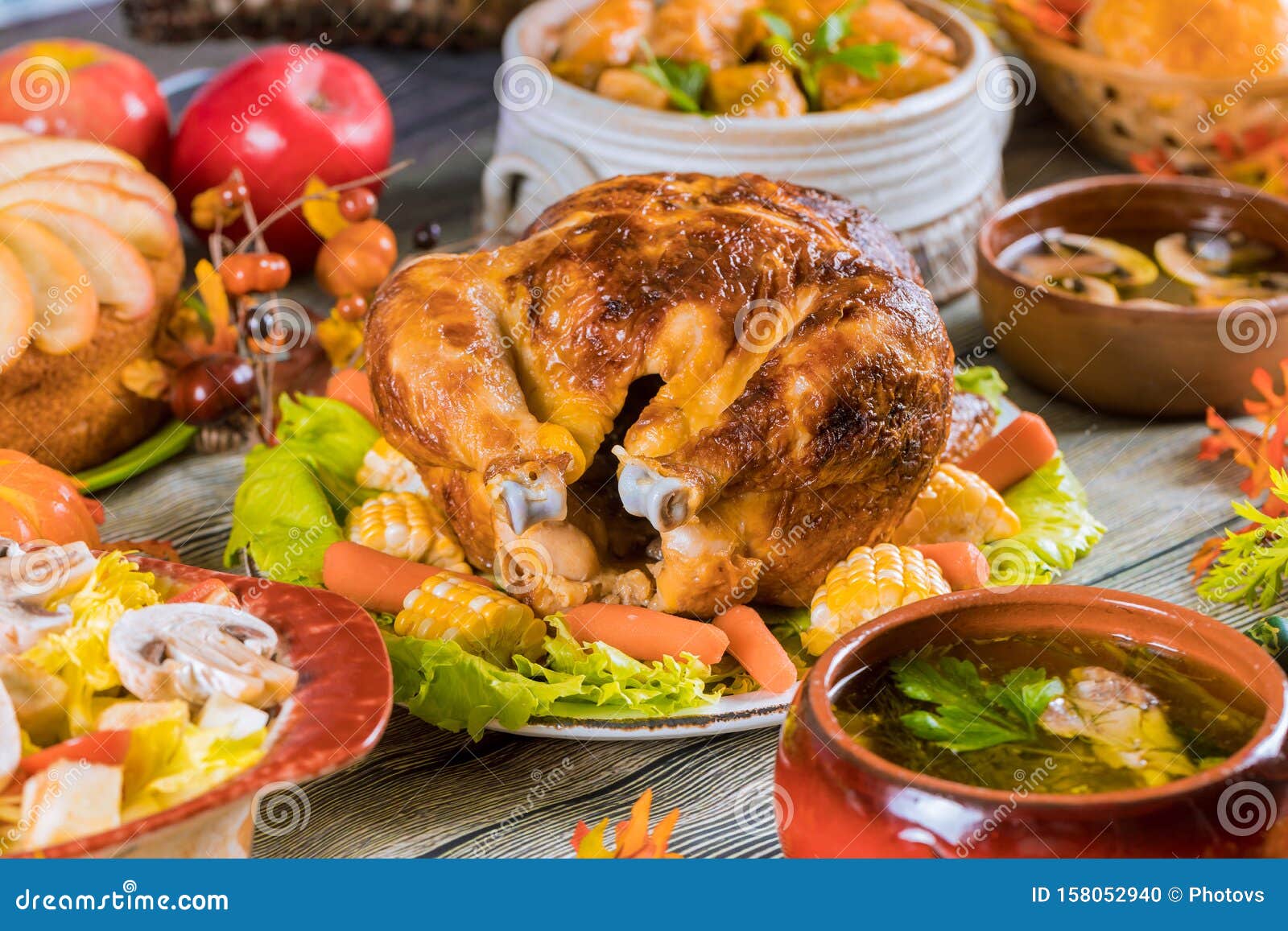 Roasted Turkey Garnished with Corn and Many Dishes on a Rustic Table ...