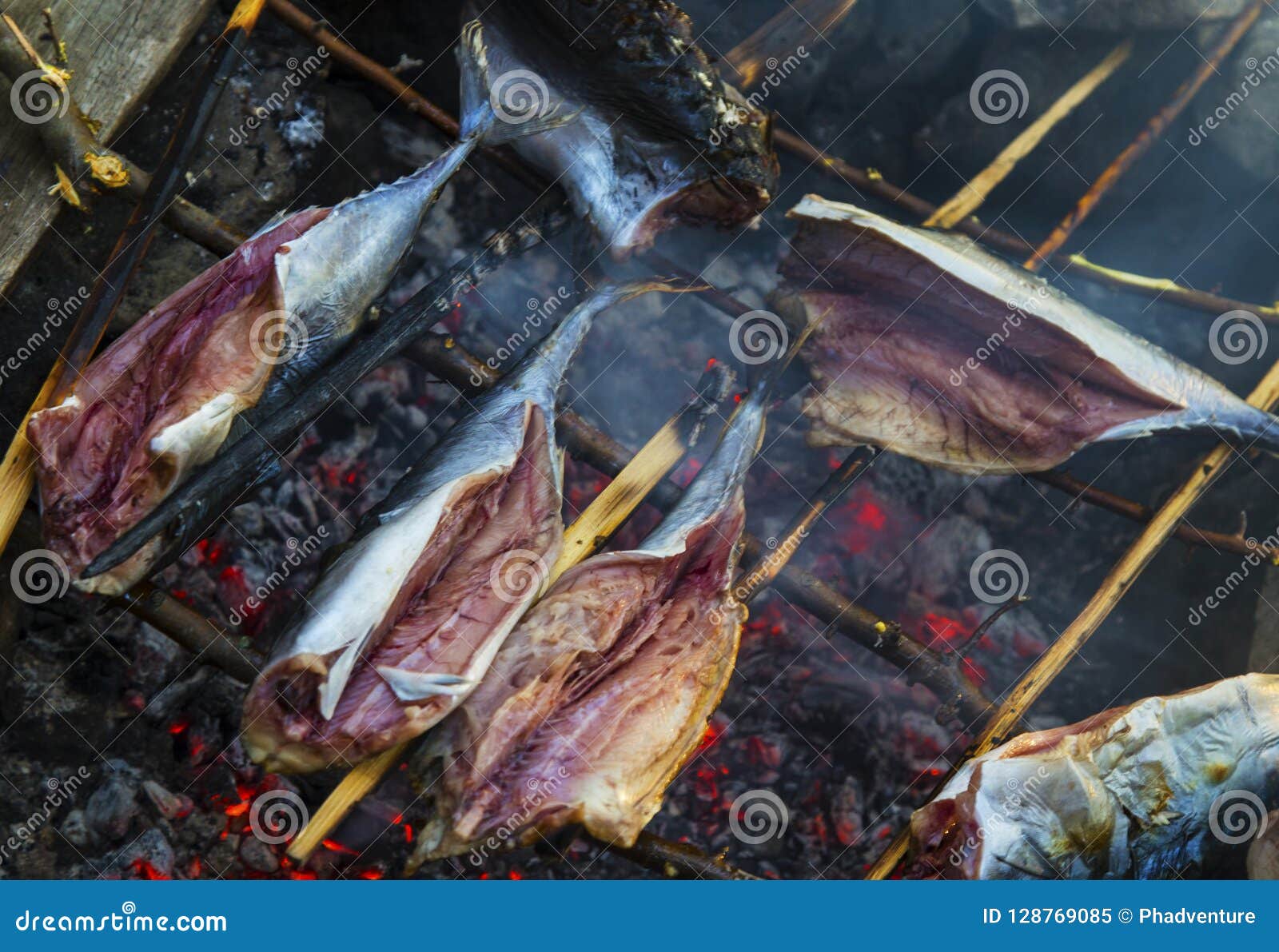 Roasting fish on fire stock image. Image of cooking - 128769085
