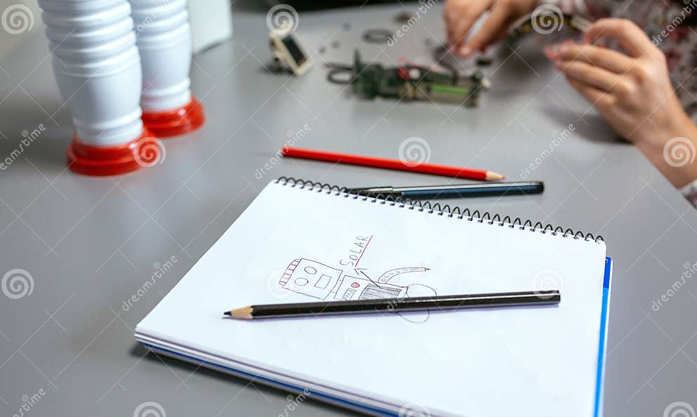 Robot Draw by Child on Notebook and Student Assembling Pieces of Toy in ...