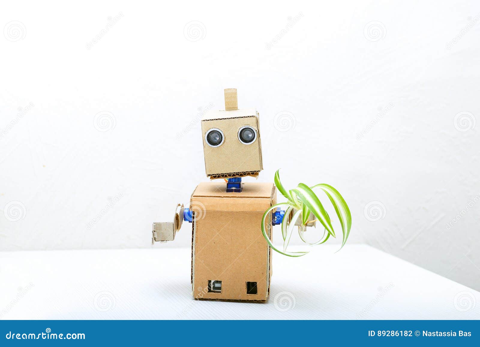 Robot with Hands on the Table and Holding a Green Flower in His Stock ...