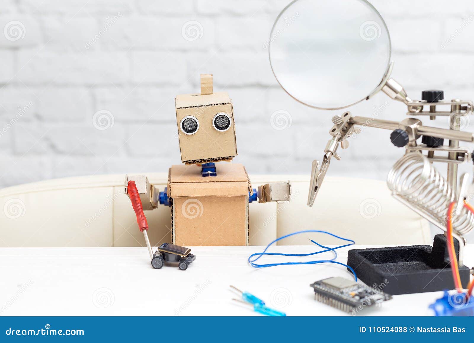 The Robot Holds a Screwdriver in His Hand and Collects the Machine on a ...