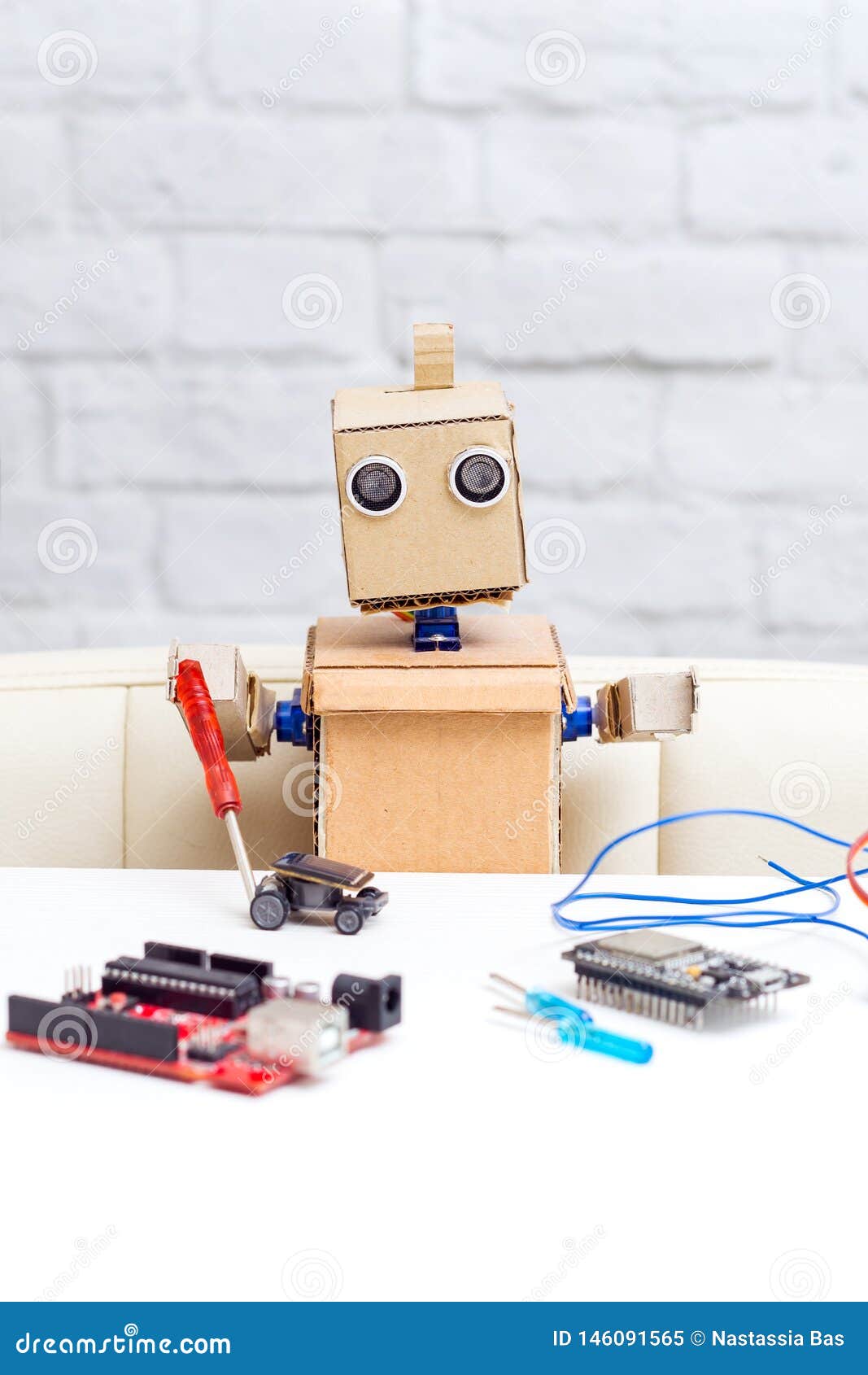 The Robot is Sitting at Your Desk and Holding a Screwdriver. Artificial ...