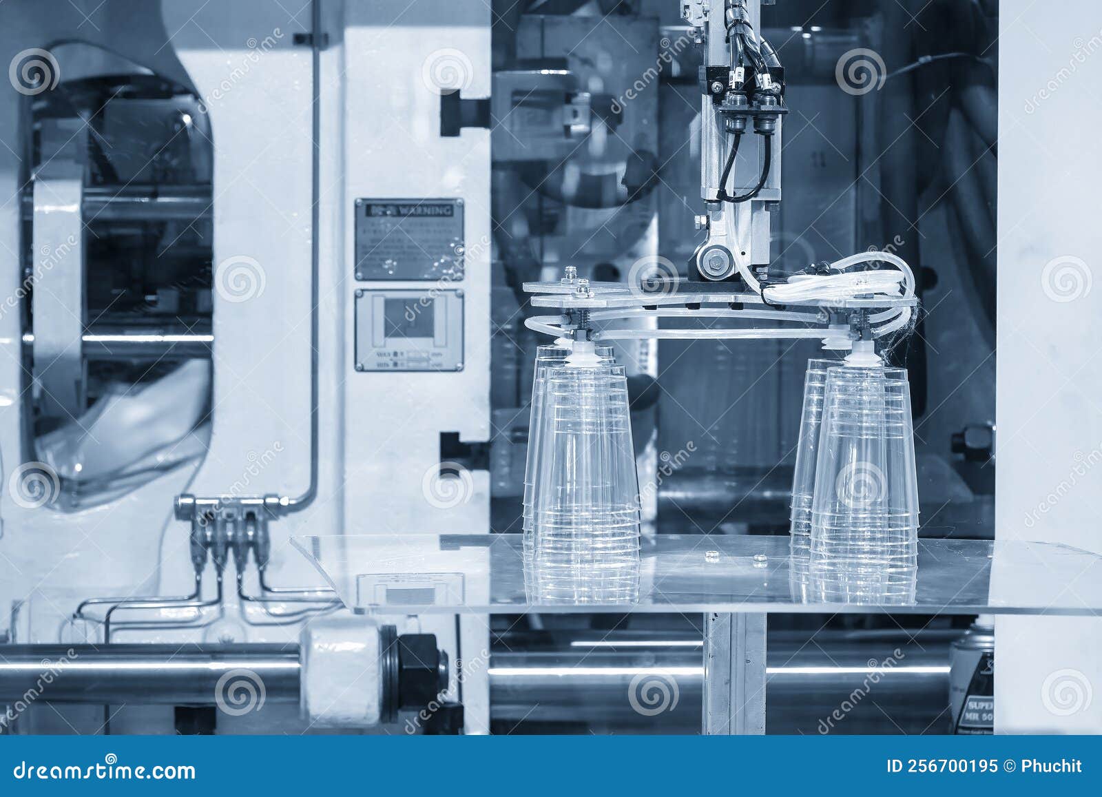 The Robotic Arm Gripping the Plastic Cup from the Injection Machine ...