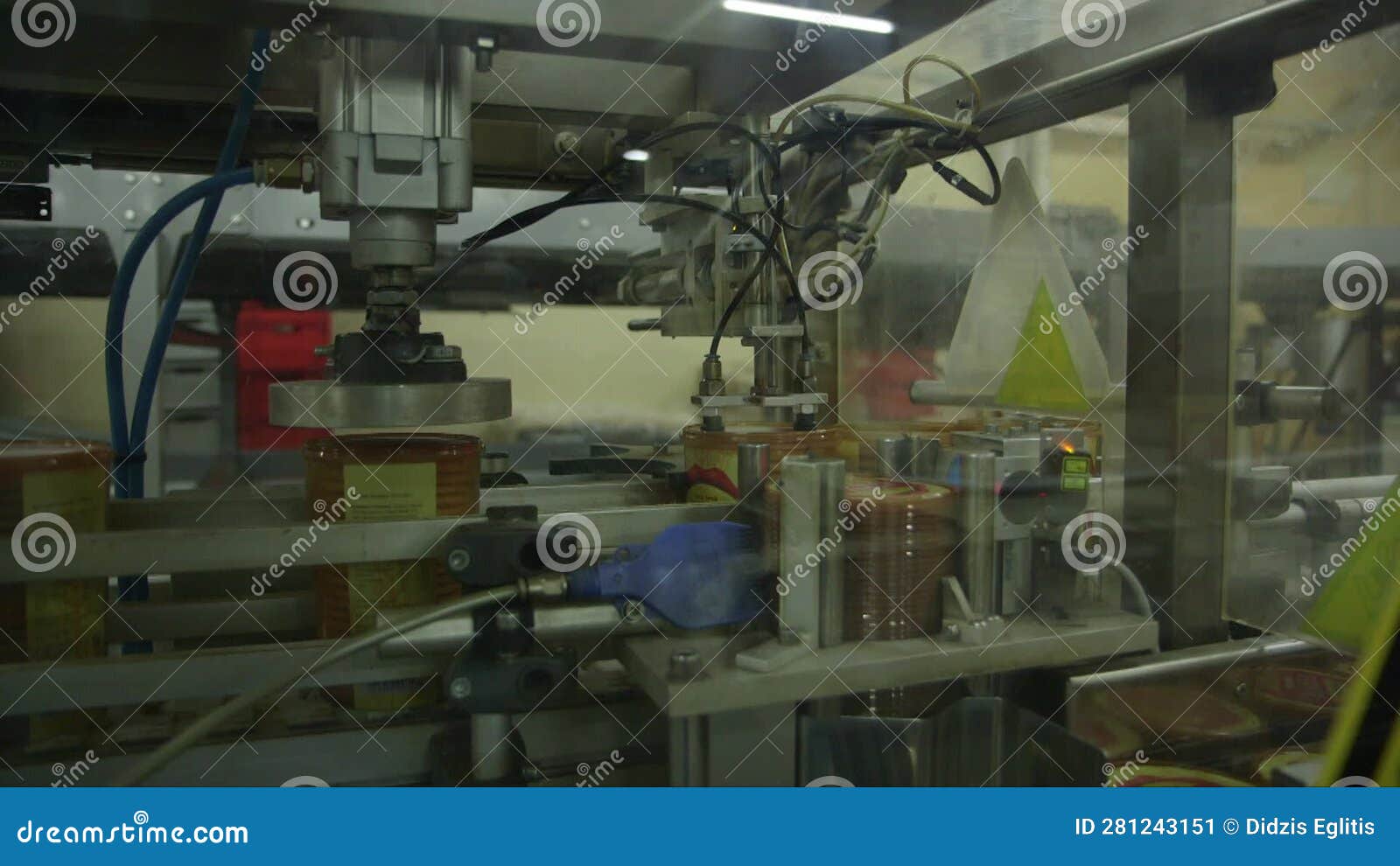 Robotic Machine Puts Plastic Caps on Cracker Packages in a Food Factory ...