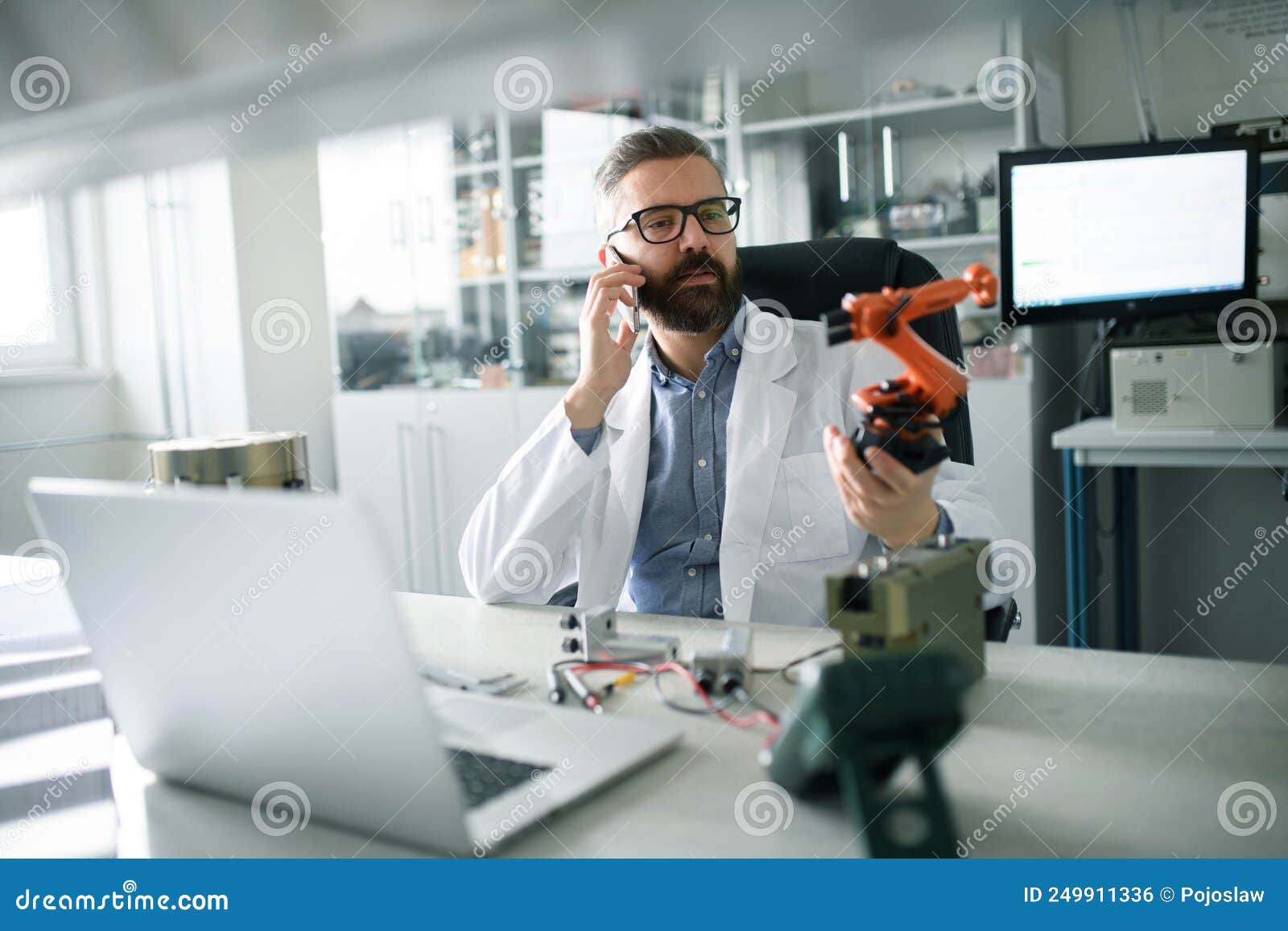 Robotics Engineer Calling on Cellphone and Working on Desing of Modern ...