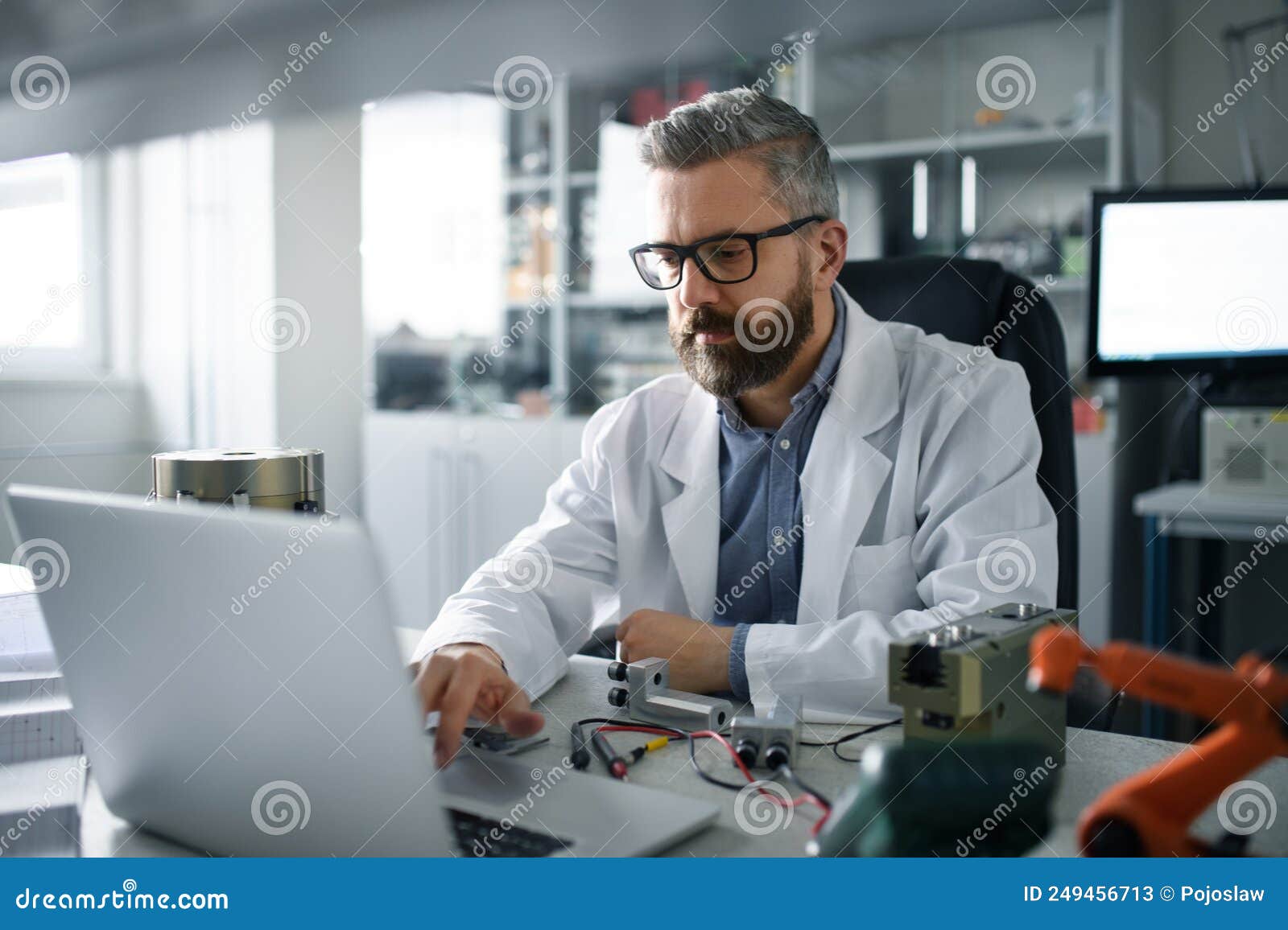 Robotics Engineer Working on Desing of Modern Robotic Arm Aand Sitting ...