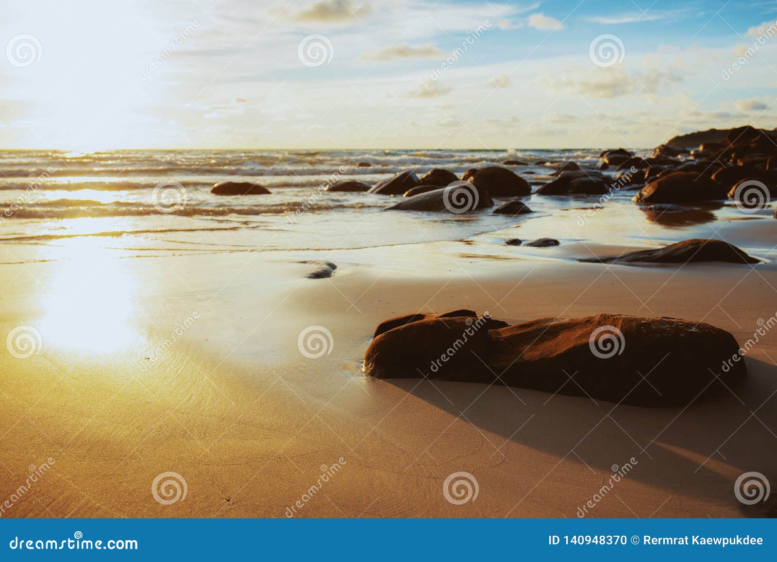 Rock on beach at sunset stock photo. Image of lounger - 140948370