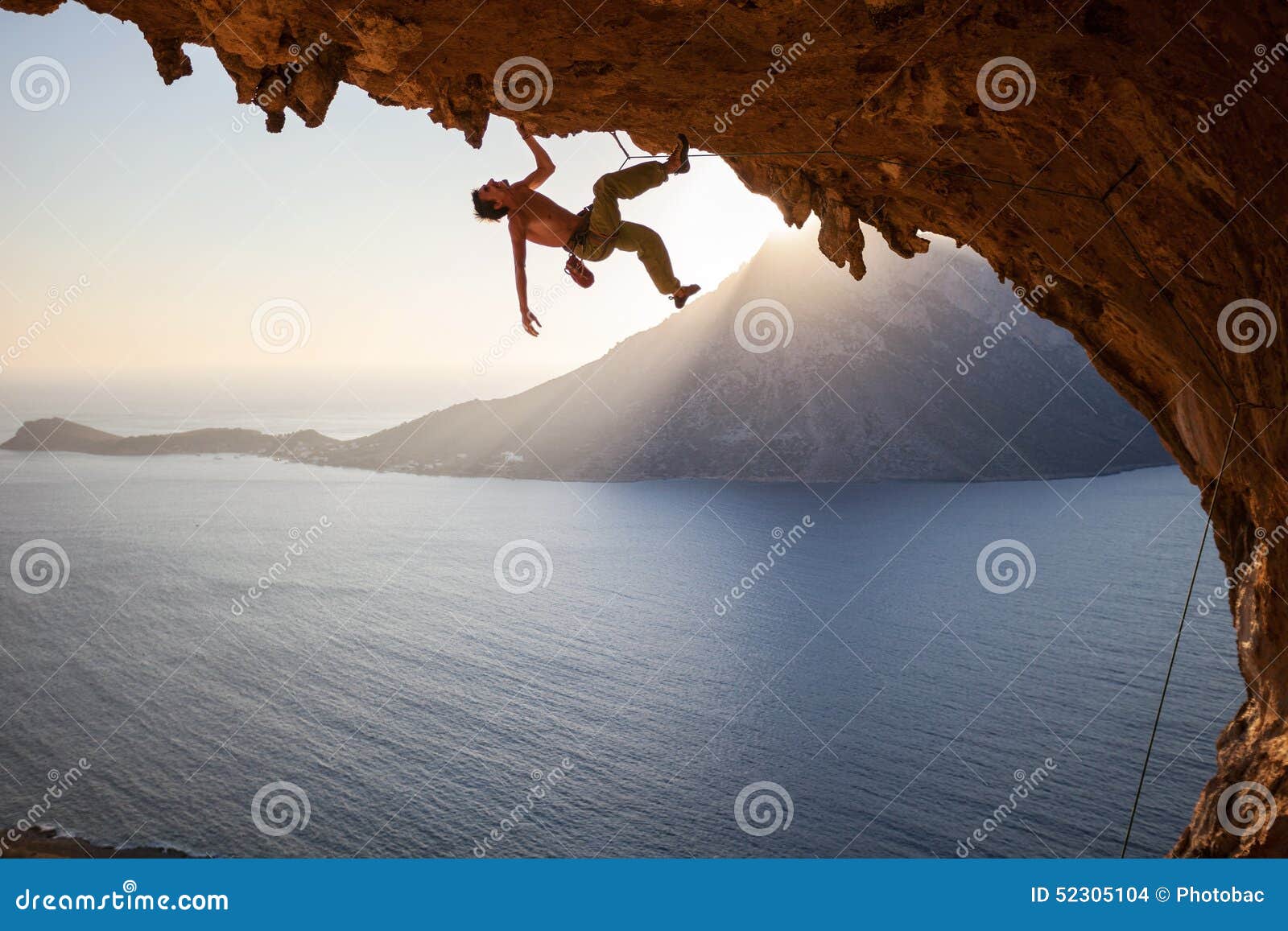 Rock Climber Climbing Along Roof in Cave at Sunset Stock Photo - Image ...