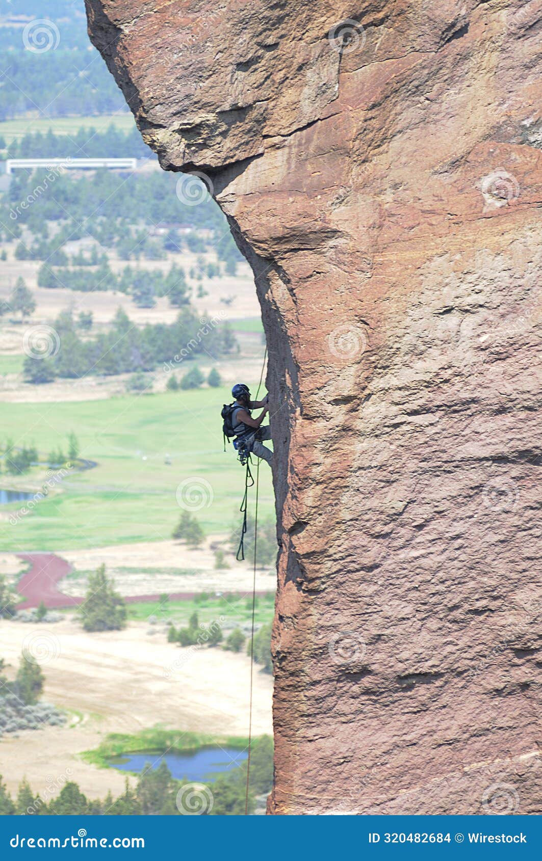 A Rock Climber Hanging from the Side of a Cliff Stock Photo - Image of ...