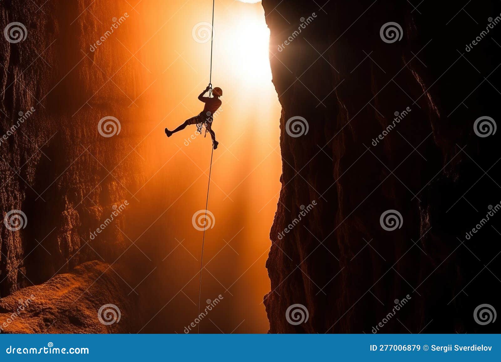 Rock Climber Hangs on a Rope in a Deep Abyss, the Sunlight Filtering ...