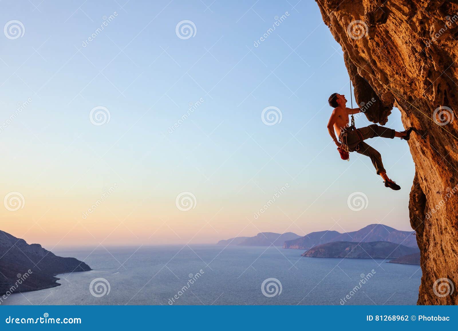 Rock Climber Resting while Climbing Cliff Stock Photo - Image of ...