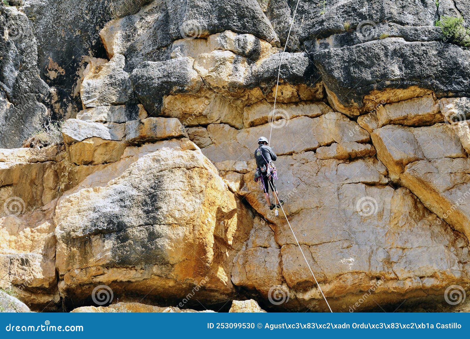 A Rock Climber with a Safety Rope, Climbing on a Flat Rock with Cracks ...