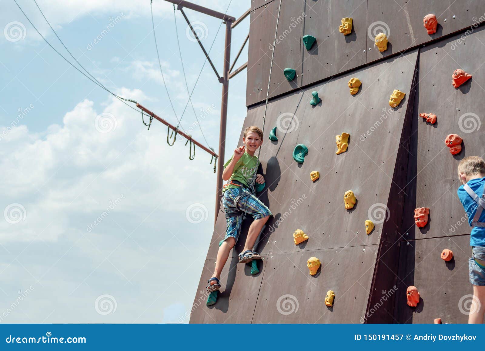 Rock Climbing on an Artificial Rise. the Boy Climbs on the Wall in an ...