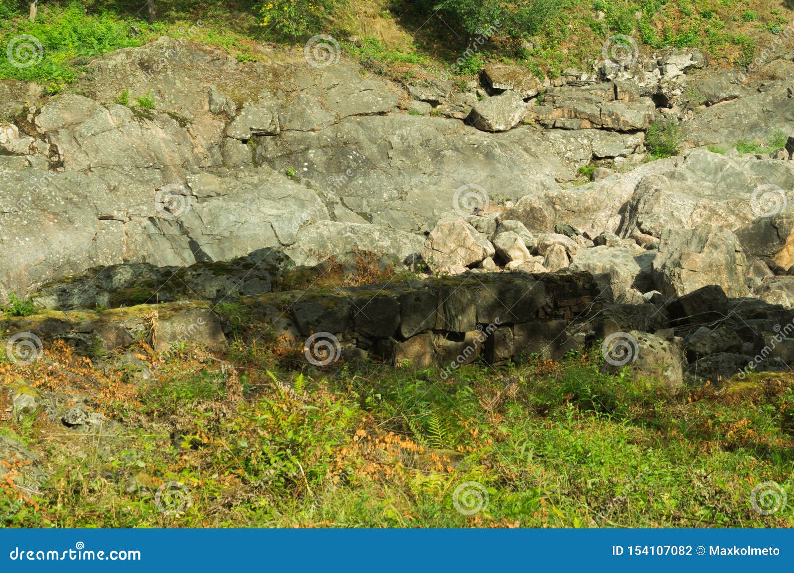 Rock of Layered Stone Overgrown with Grass and Moss. Texture of Stone ...