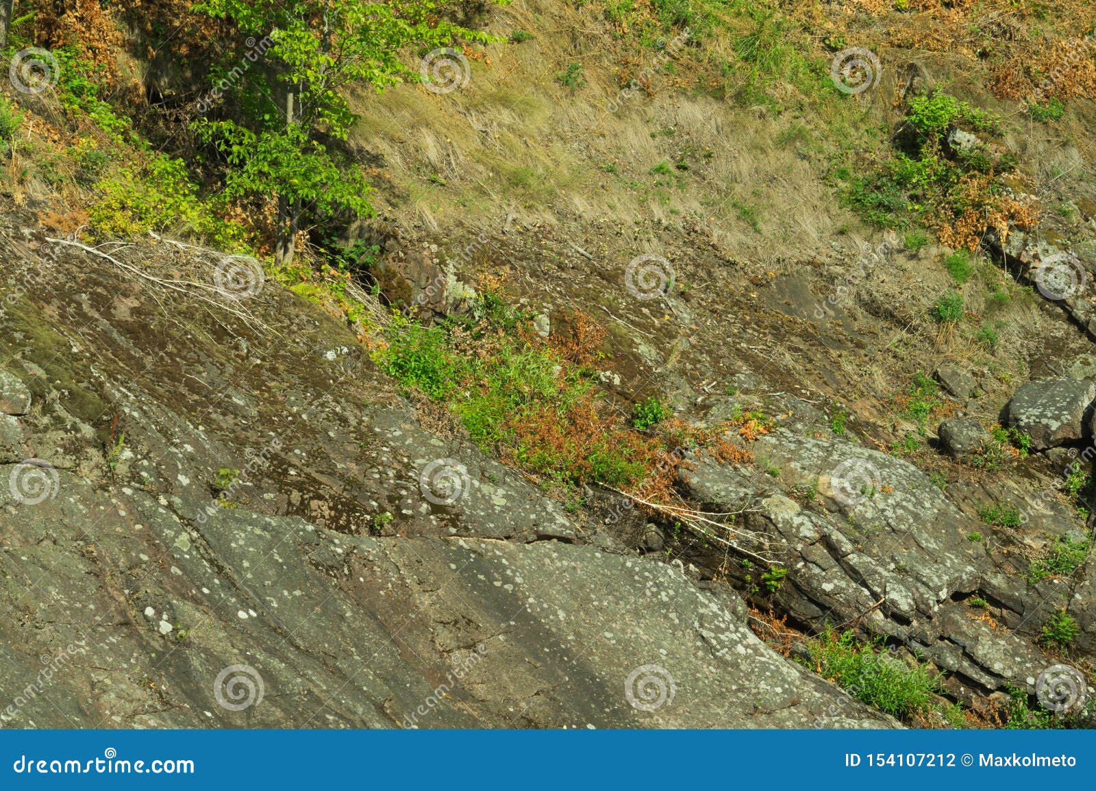Rock of Layered Stone Overgrown with Grass and Moss. Texture of Stone ...