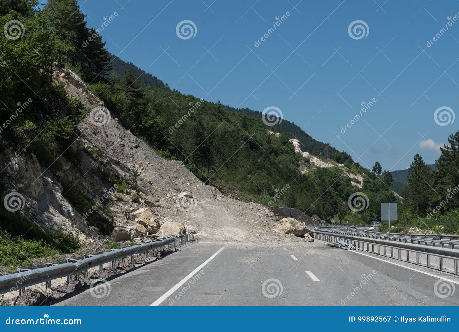Rockfall on the road stock image. Image of forest, road - 99892567