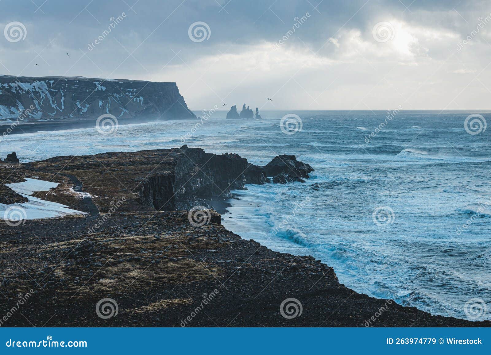 Rocks by a Coastal Cliff in the Sea before a Cloudy Skyline Stock Image ...
