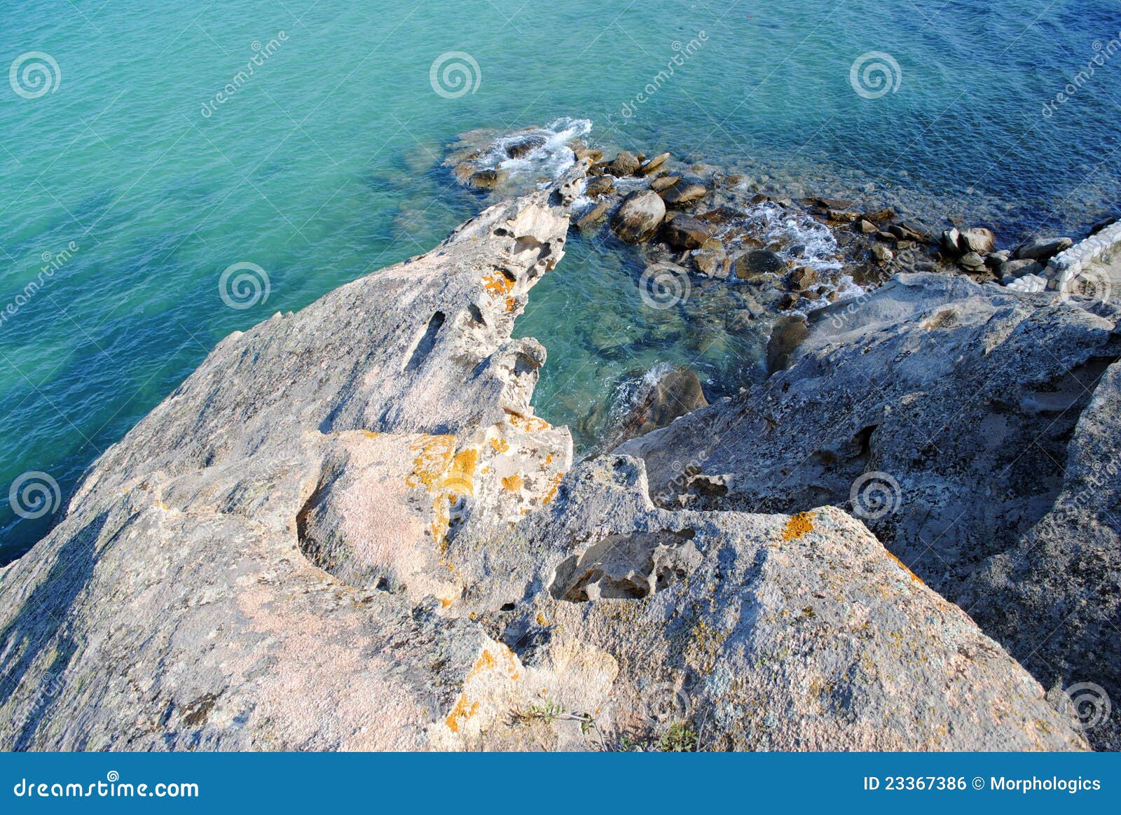 Rocks merging into the sea stock photo. Image of ocean - 23367386