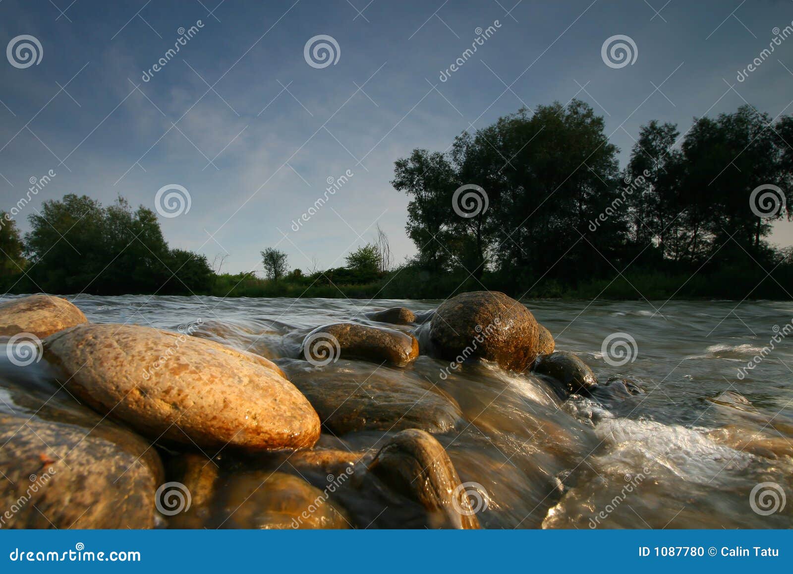 Rocks in the river bed stock photo. Image of sunrise, clouds - 1087780