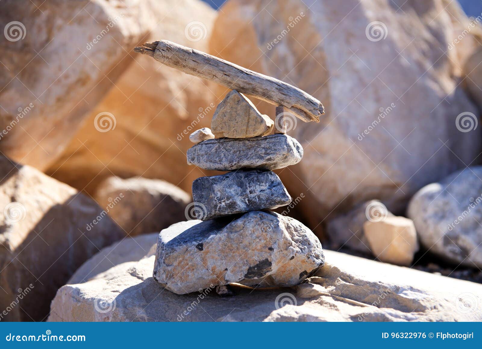 Rocks are Stacked in a Pyramid Shape with a Piece of Driftwood on Top ...