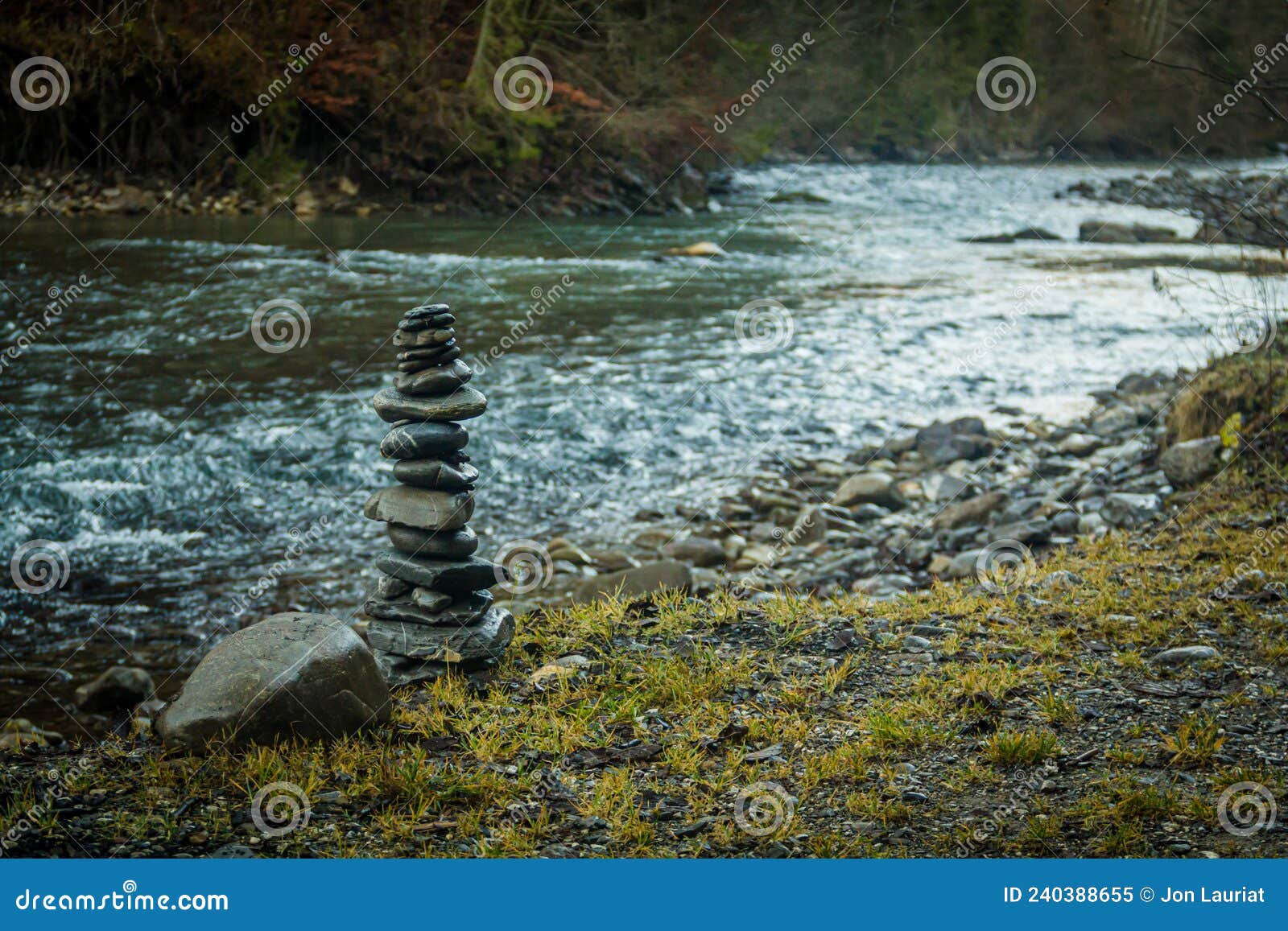Rocks Stacked in a Tower at the Edge of a River Stock Image - Image of ...